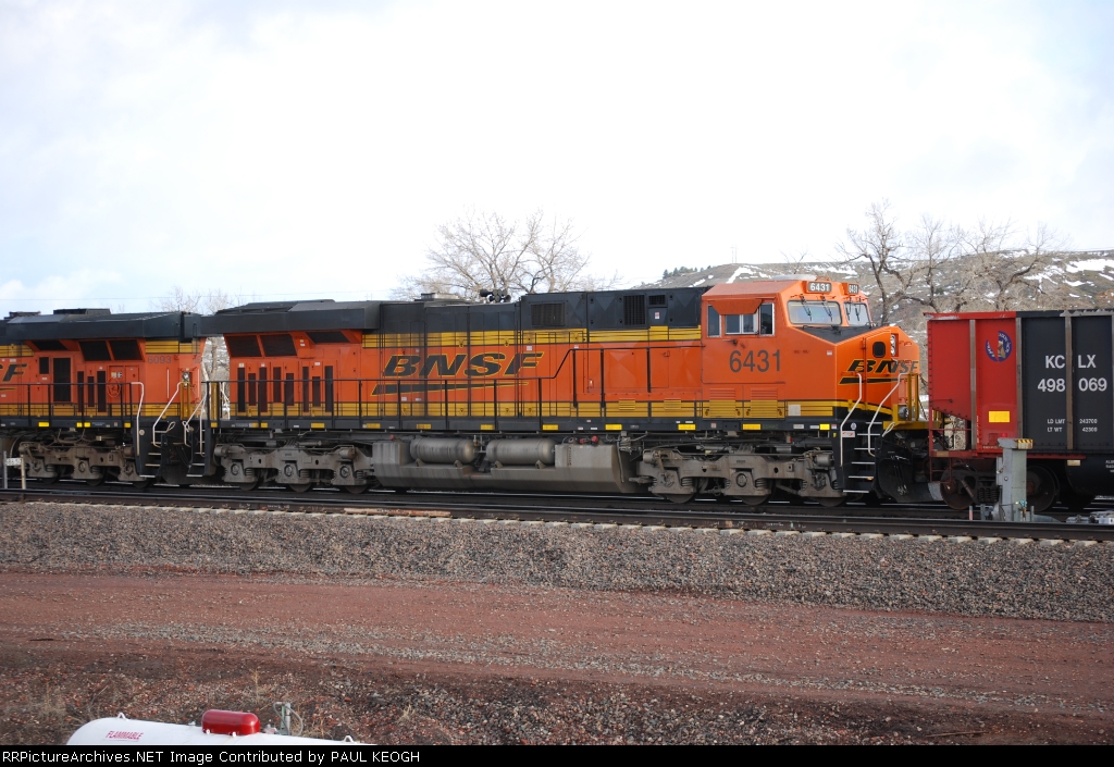 BNSF 6431 2d unit behind BNSF 6093 as they roll west pulling a KC coal power station coal cars.